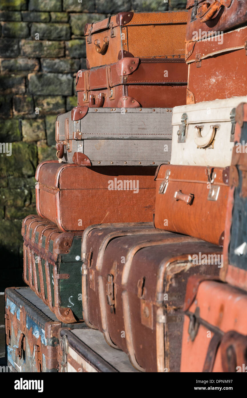 Old suitcases stacked at a railway station recreating a typical scene ...