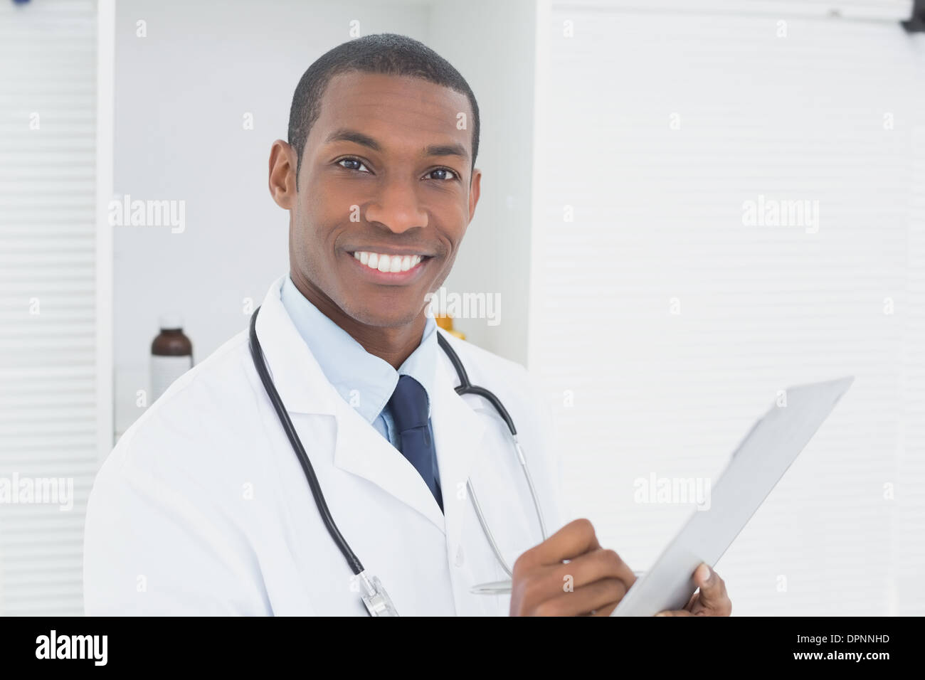 Smiling doctor writing a prescription in medical office Stock Photo - Alamy