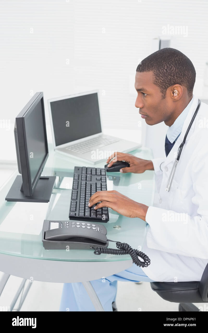 Concentrated doctor using computer at medical office Stock Photo - Alamy