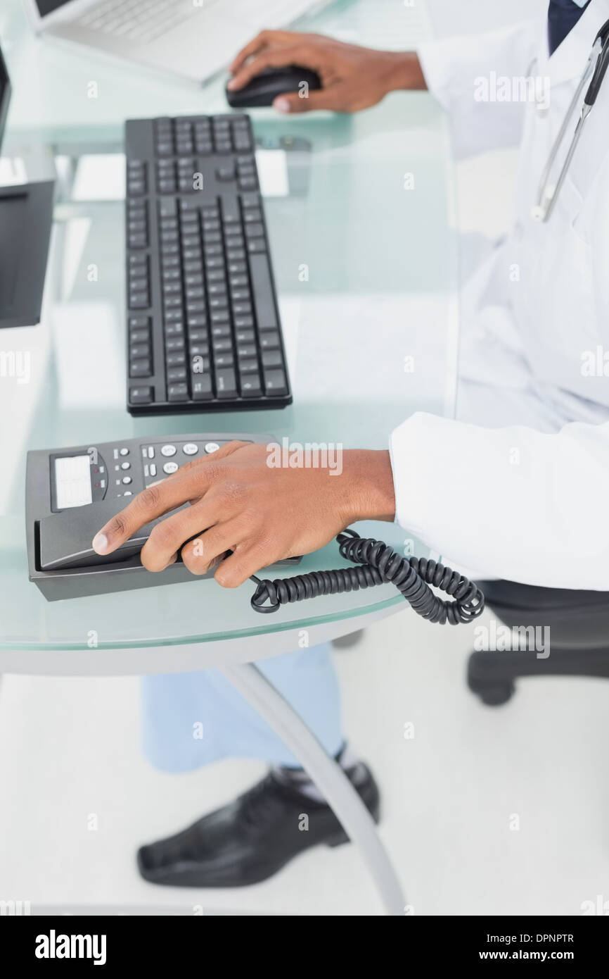 Low section of doctor using computer at medical office Stock Photo - Alamy