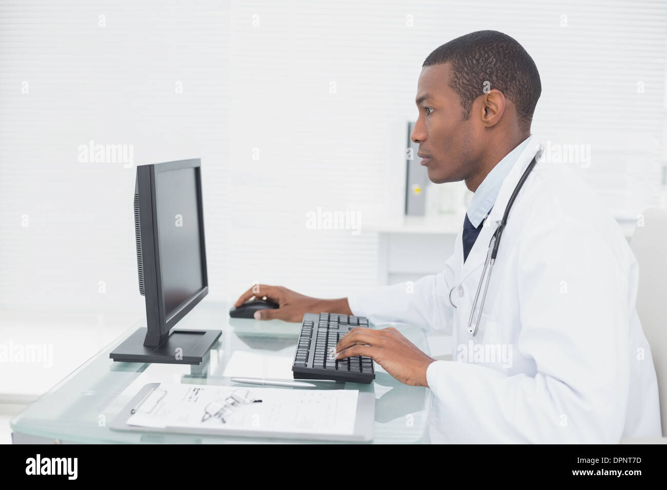 Concentrated doctor using computer at medical office Stock Photo - Alamy