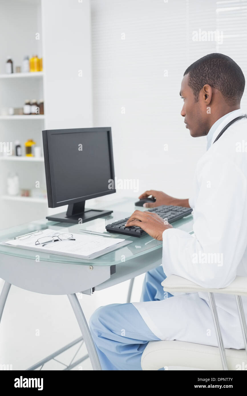 Concentrated doctor using computer at medical office Stock Photo - Alamy