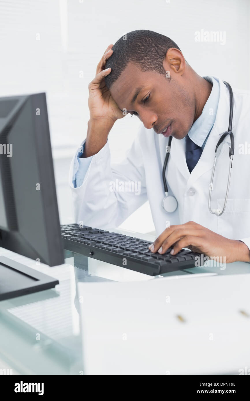 Doctor thinking while typing hi-res stock photography and images - Alamy