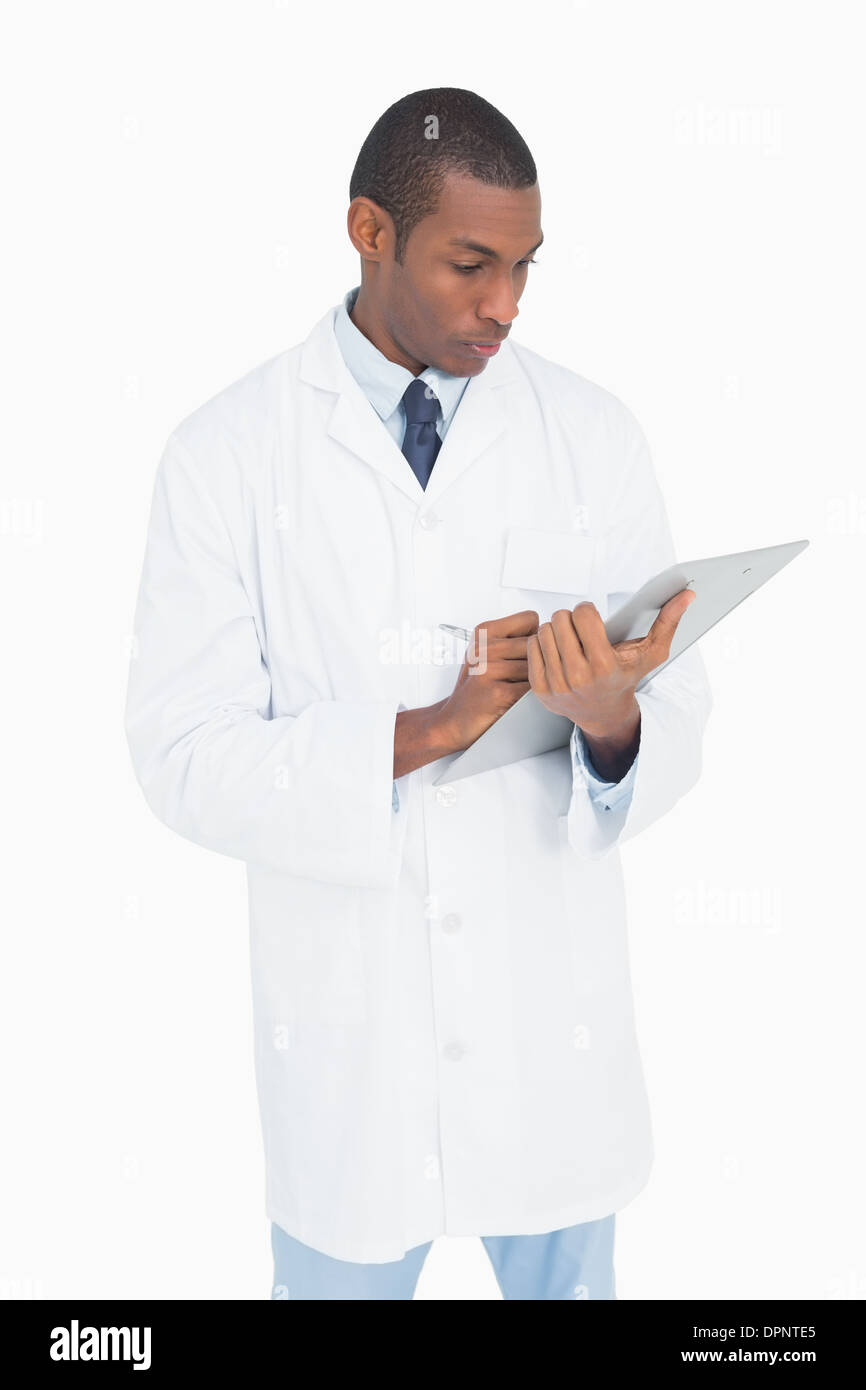 Serious male doctor writing on clipboard Stock Photo - Alamy