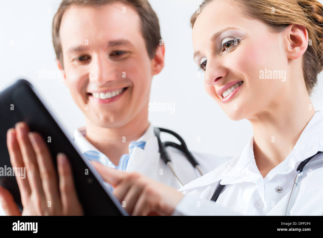 Doctors - male and female - discussing test reports that show on their ...