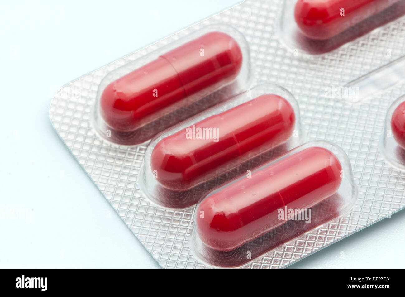 red pills on a white background Stock Photo - Alamy