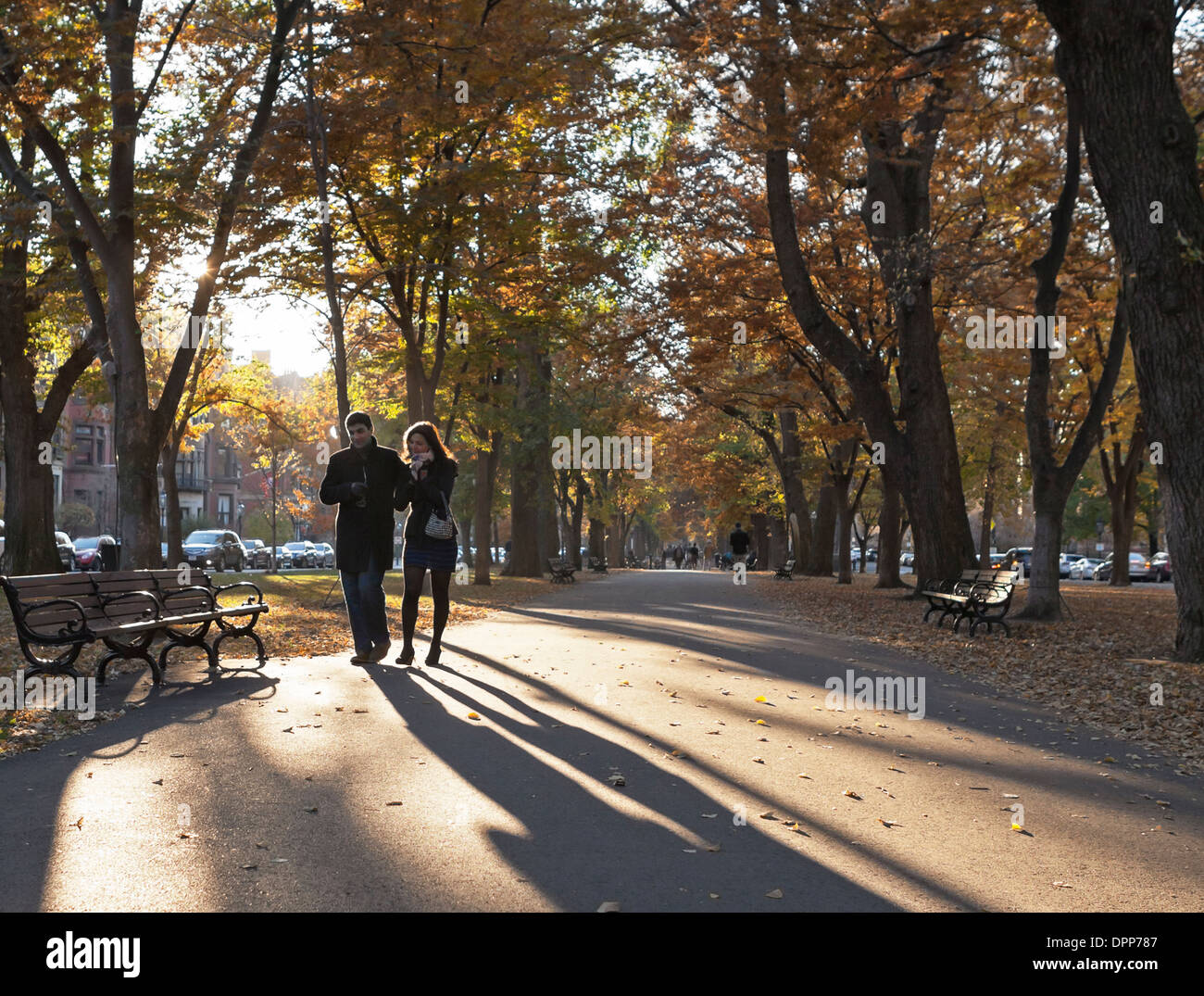 A man and woman walk together on Commonwealth Avenue Mall in Boston ...