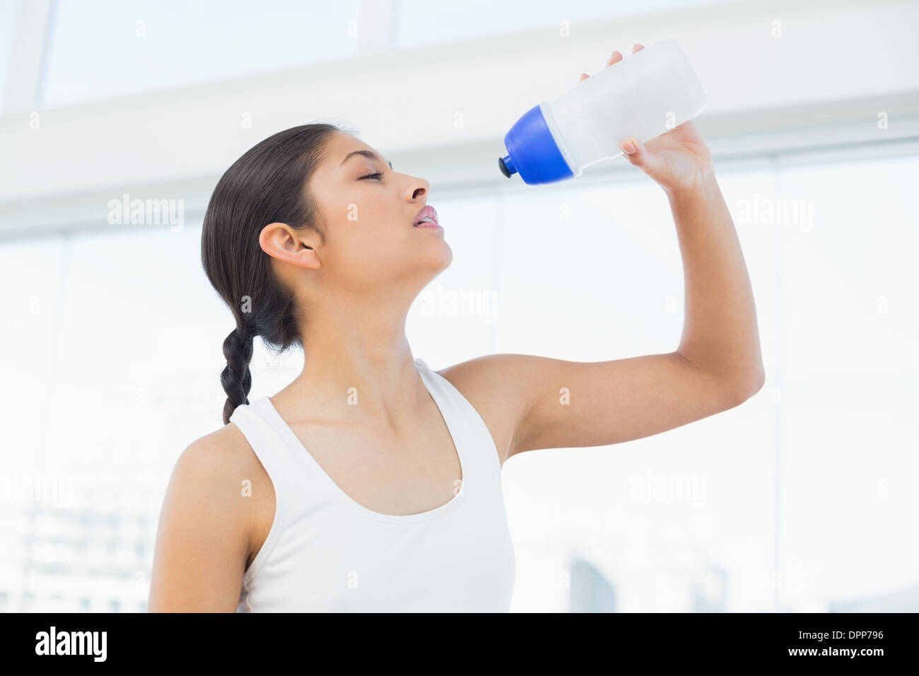 Fit woman drinking water in fitness studio Stock Photo - Alamy