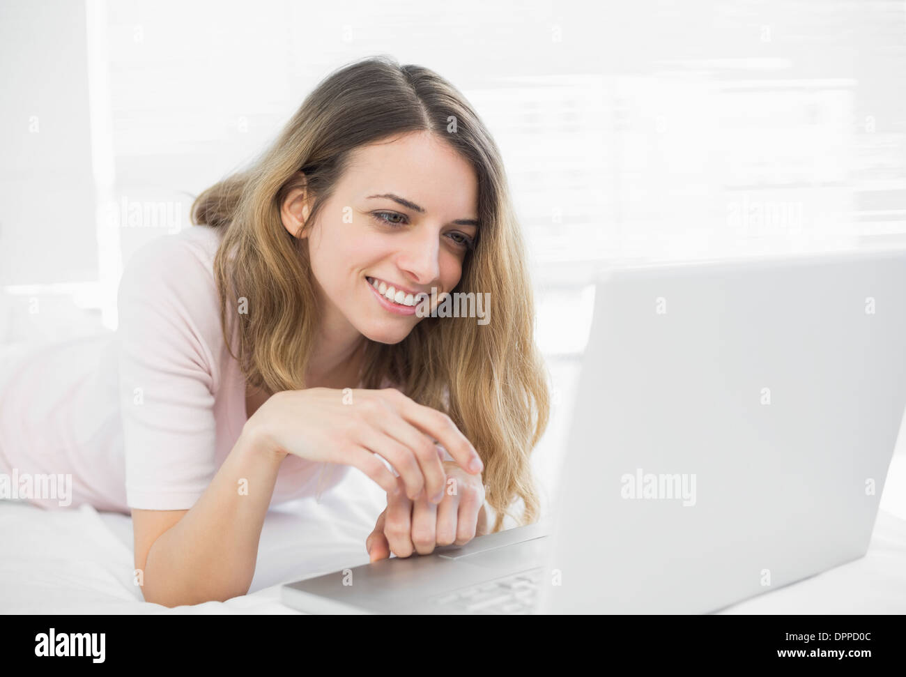 Attractive woman making smiling use of her notebook Stock Photo - Alamy