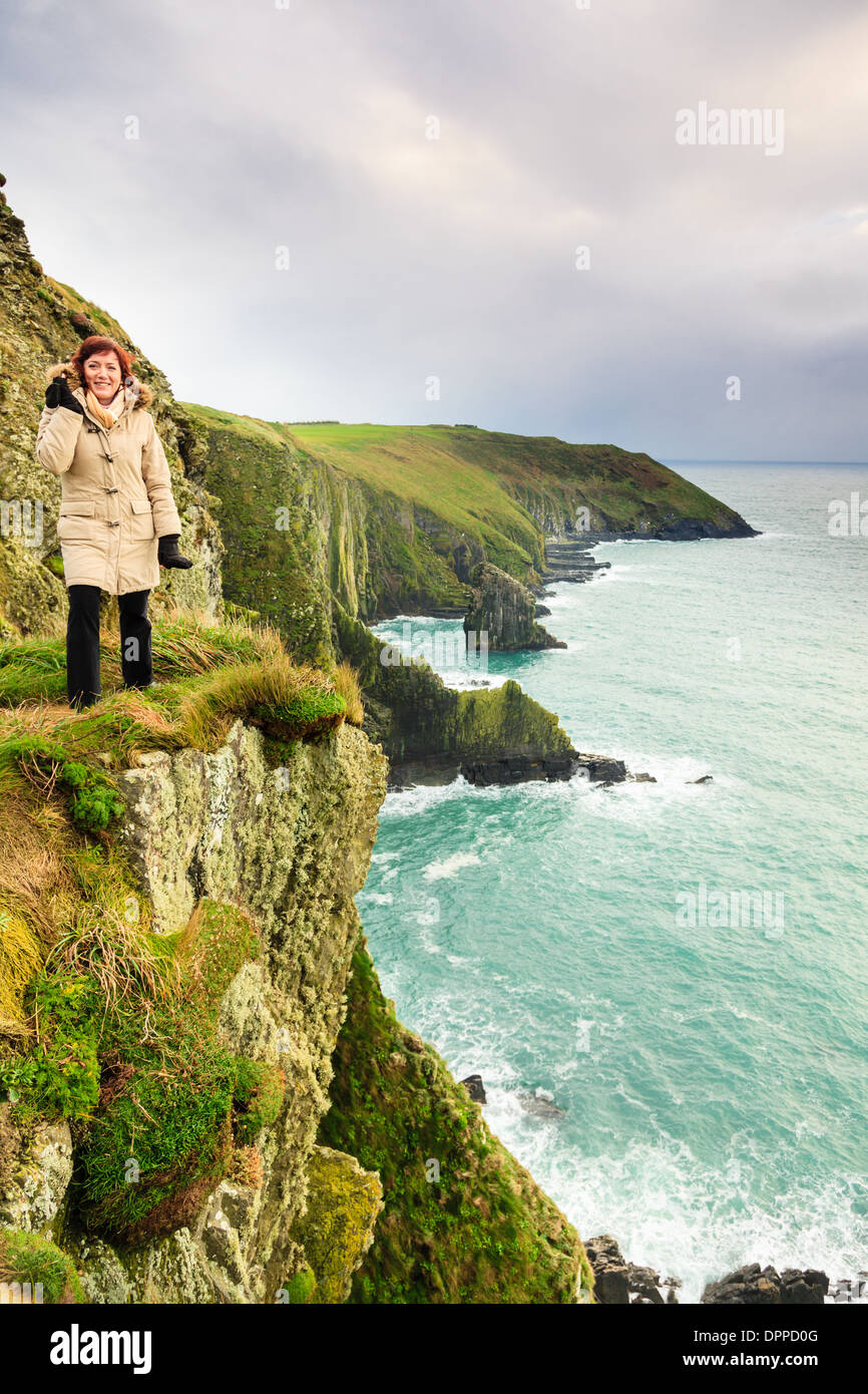Irish atlantic coast. Woman tourist standing on rock cliff by the ocean ...
