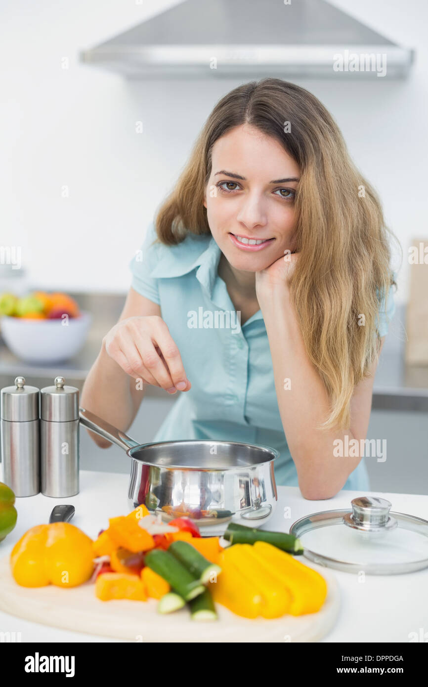 Young cute woman cooking while smiling at camera Stock Photo - Alamy