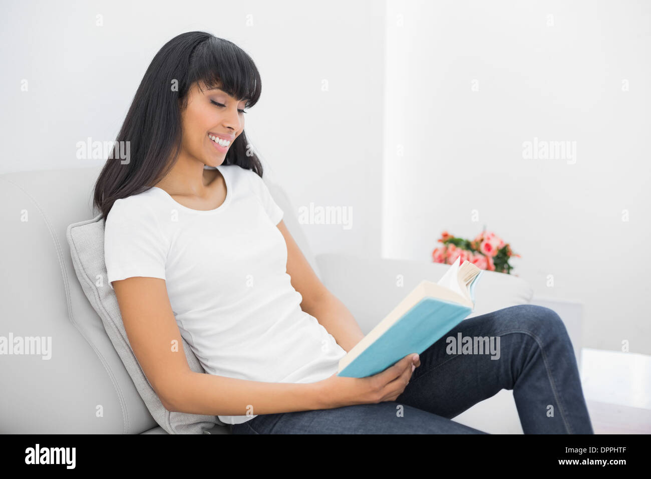 Lovely calm woman reading a book sitting on couch Stock Photo - Alamy
