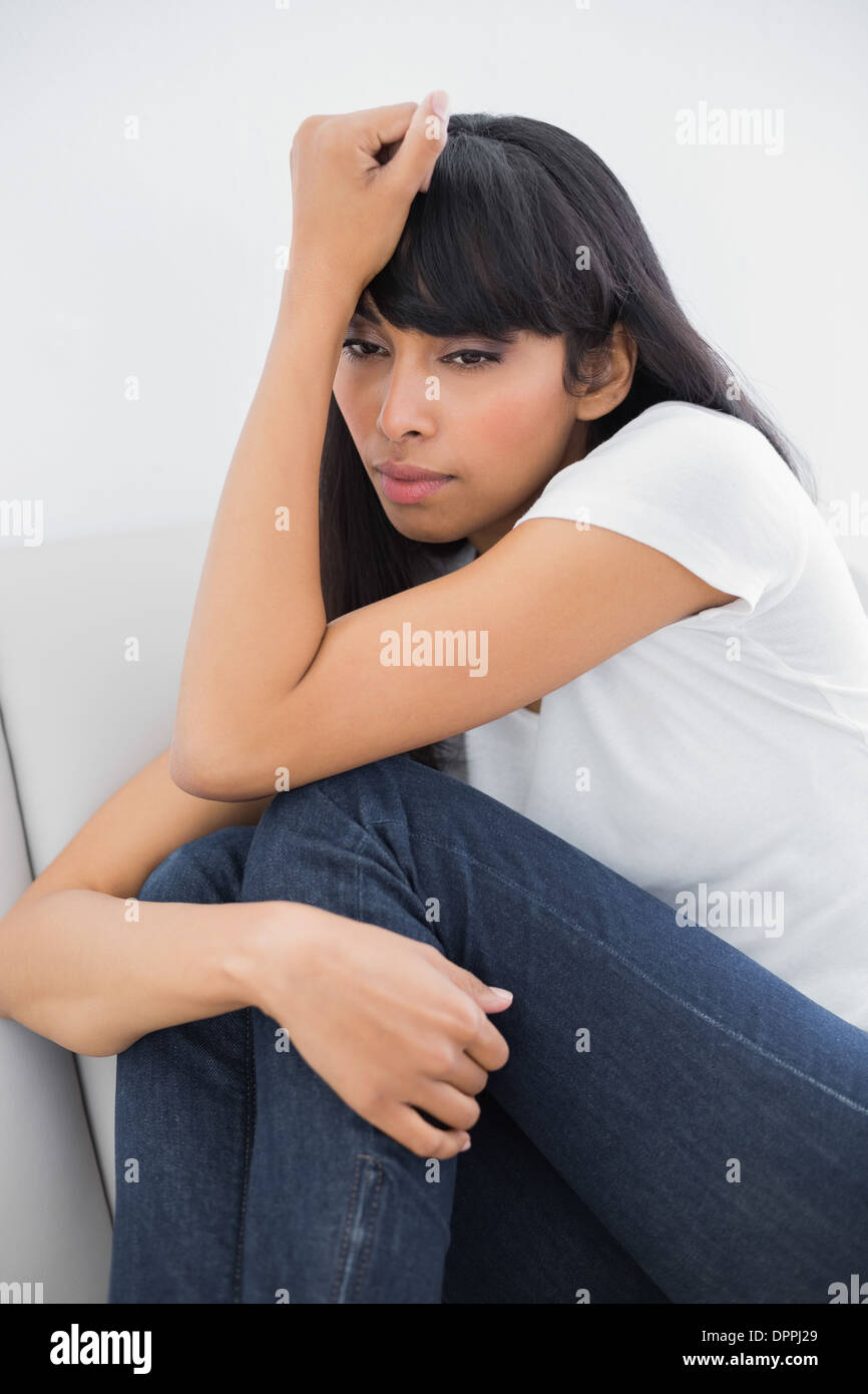 Thinking calm woman sitting on couch Stock Photo - Alamy
