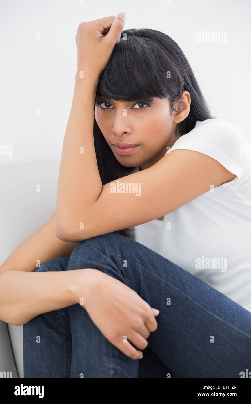 Beautiful thinking woman sitting on couch in bright living room Stock ...