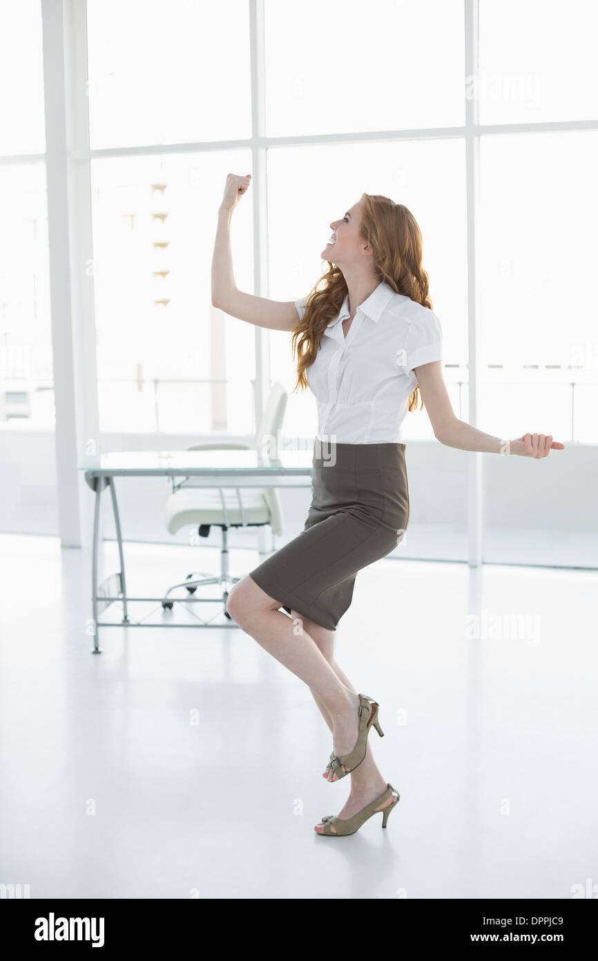 Cheerful elegant businesswoman cheering in office Stock Photo - Alamy
