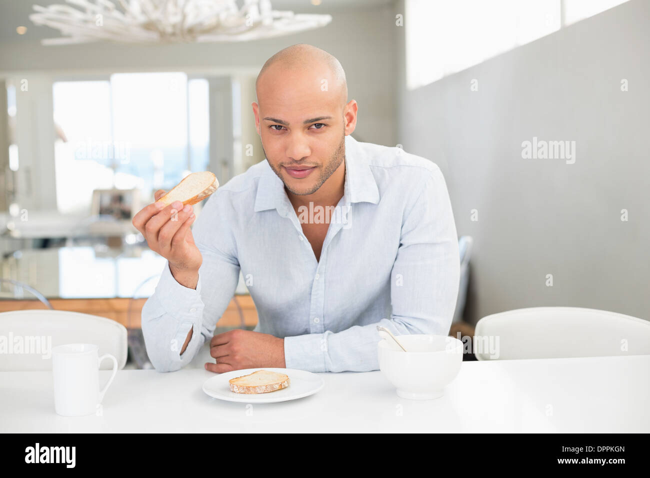 Young man eating breakfast sitting hi-res stock photography and images ...