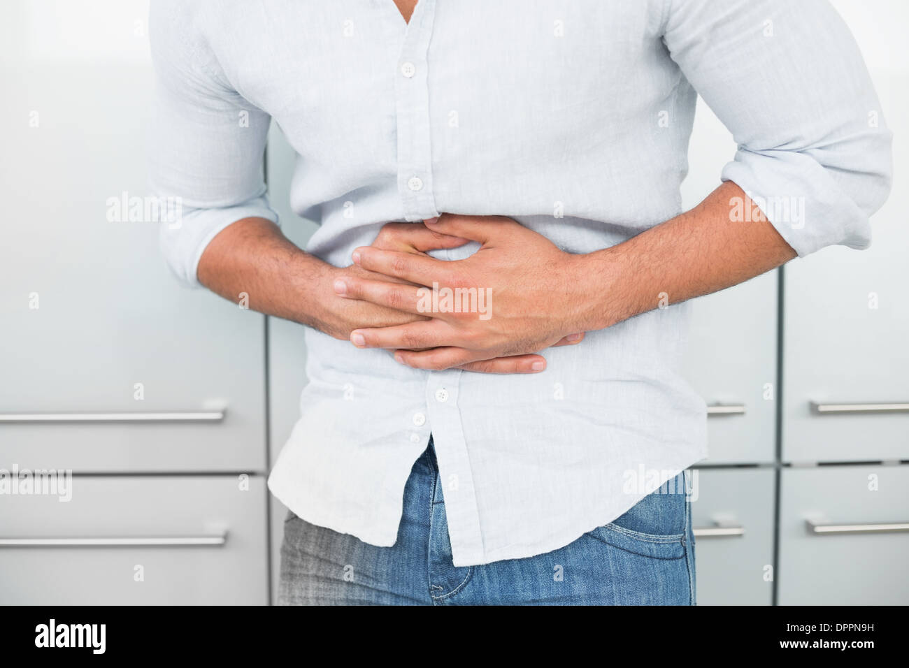 Mid section of man suffering from stomach pain Stock Photo - Alamy