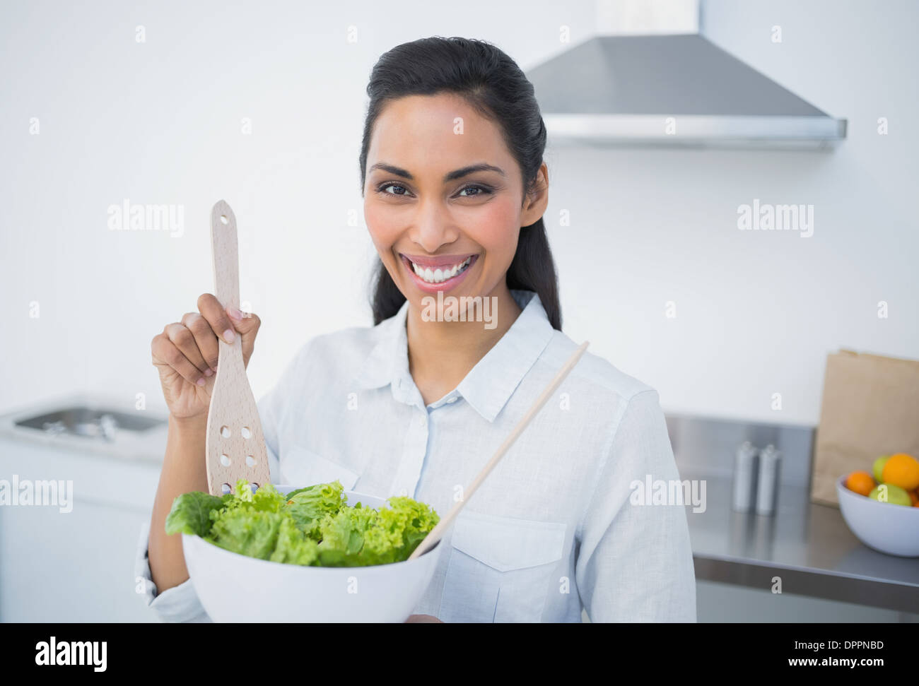 Beautiful smiling woman showing salad smiling at camera Stock Photo - Alamy