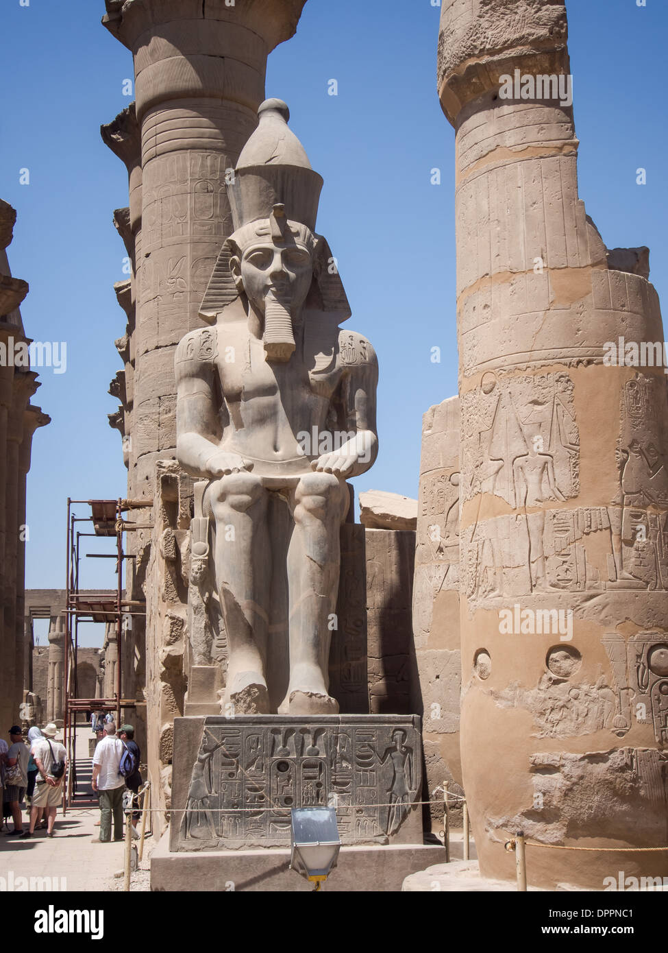 One of two seated statues of Rameses II guard the huge pylon to the ...