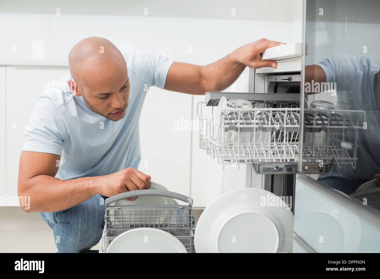 Serious man using dish washer in kitchen Stock Photo - Alamy