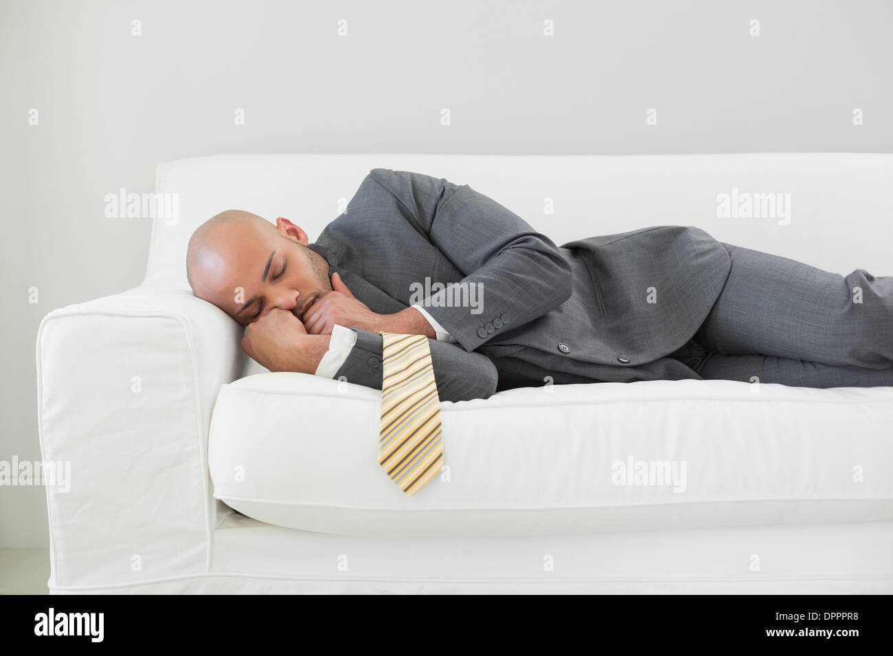 Elegant businessman sleeping on sofa Stock Photo - Alamy