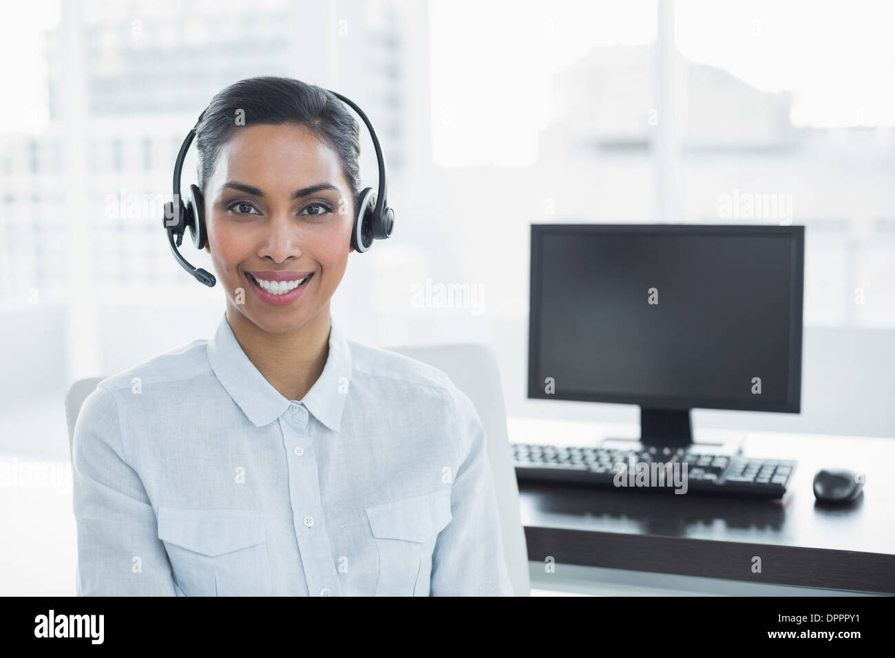 Attractive female agent wearing headset smiling at camera Stock Photo ...