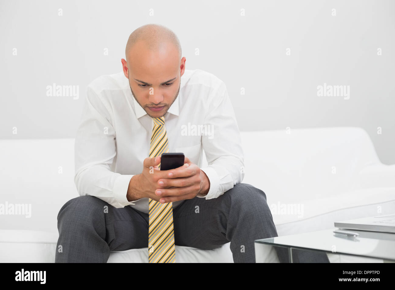 Serious young businessman text messaging Stock Photo - Alamy