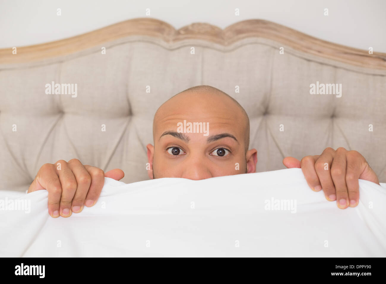 Shocked bald man covering face with sheet in bed Stock Photo - Alamy