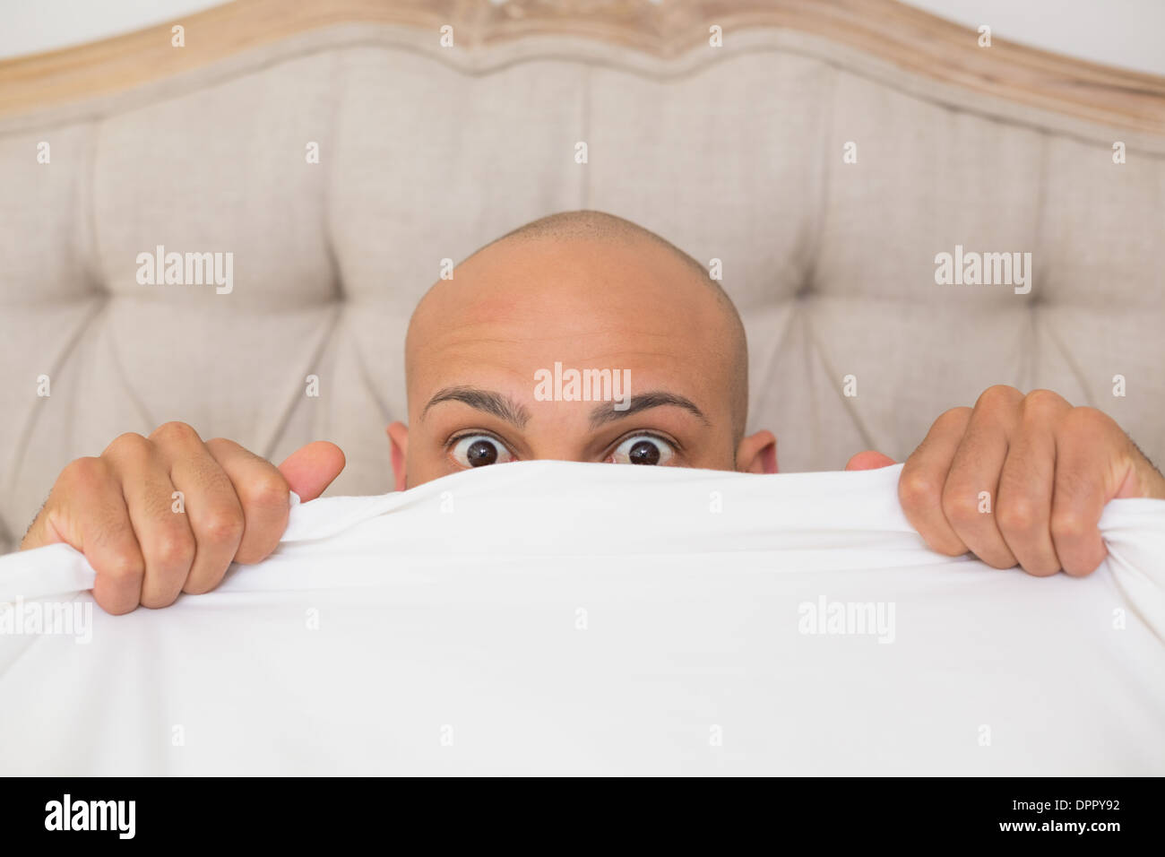 Shocked bald man covering face with sheet in bed Stock Photo - Alamy