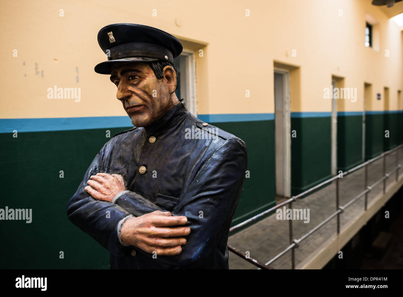 A life-sized model of a prison guard looking down over the cell blocks ...