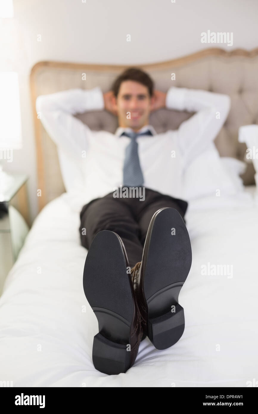 Relaxed smiling well dressed man lying in bed Stock Photo - Alamy