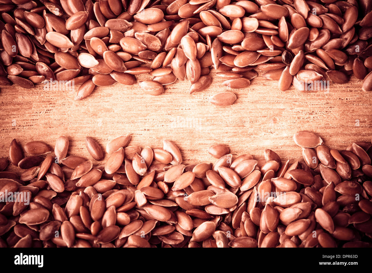 Healthy diet organic nutrition. Brown raw flax seeds linseed border frame on wooden table ...