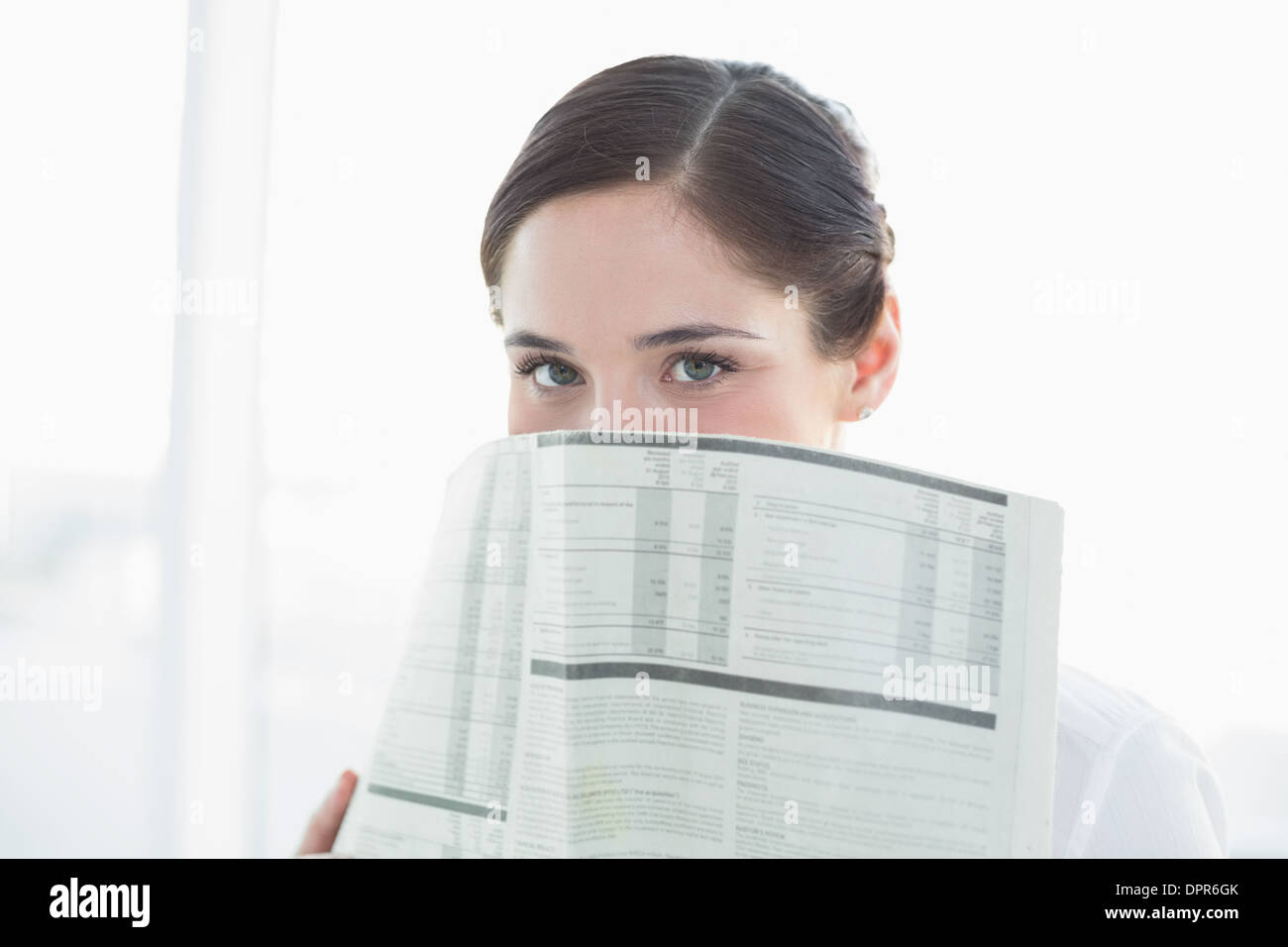 Business woman holding newspaper in front of face Stock Photo - Alamy