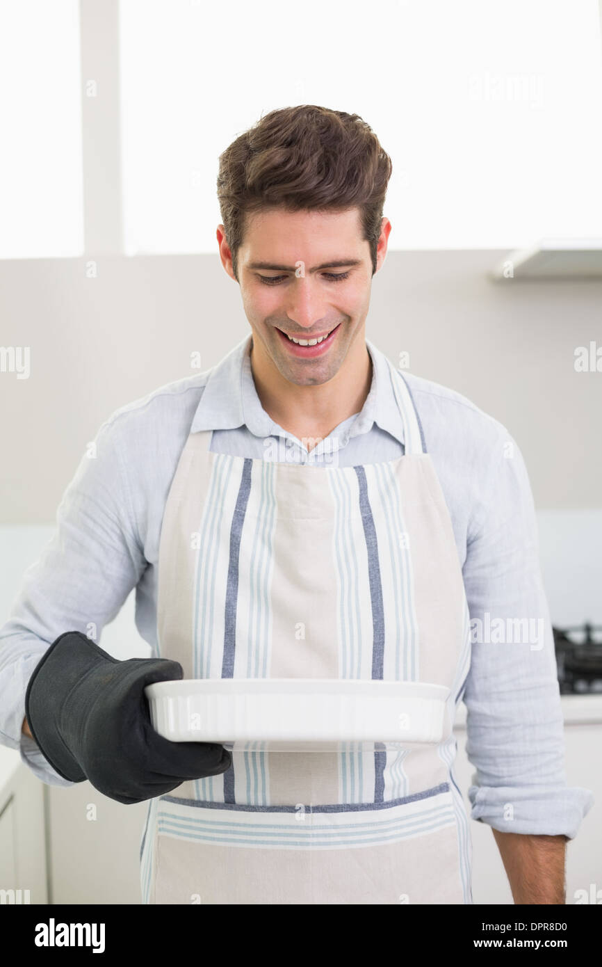 Smiling man holding baking dish hi-res stock photography and images - Alamy