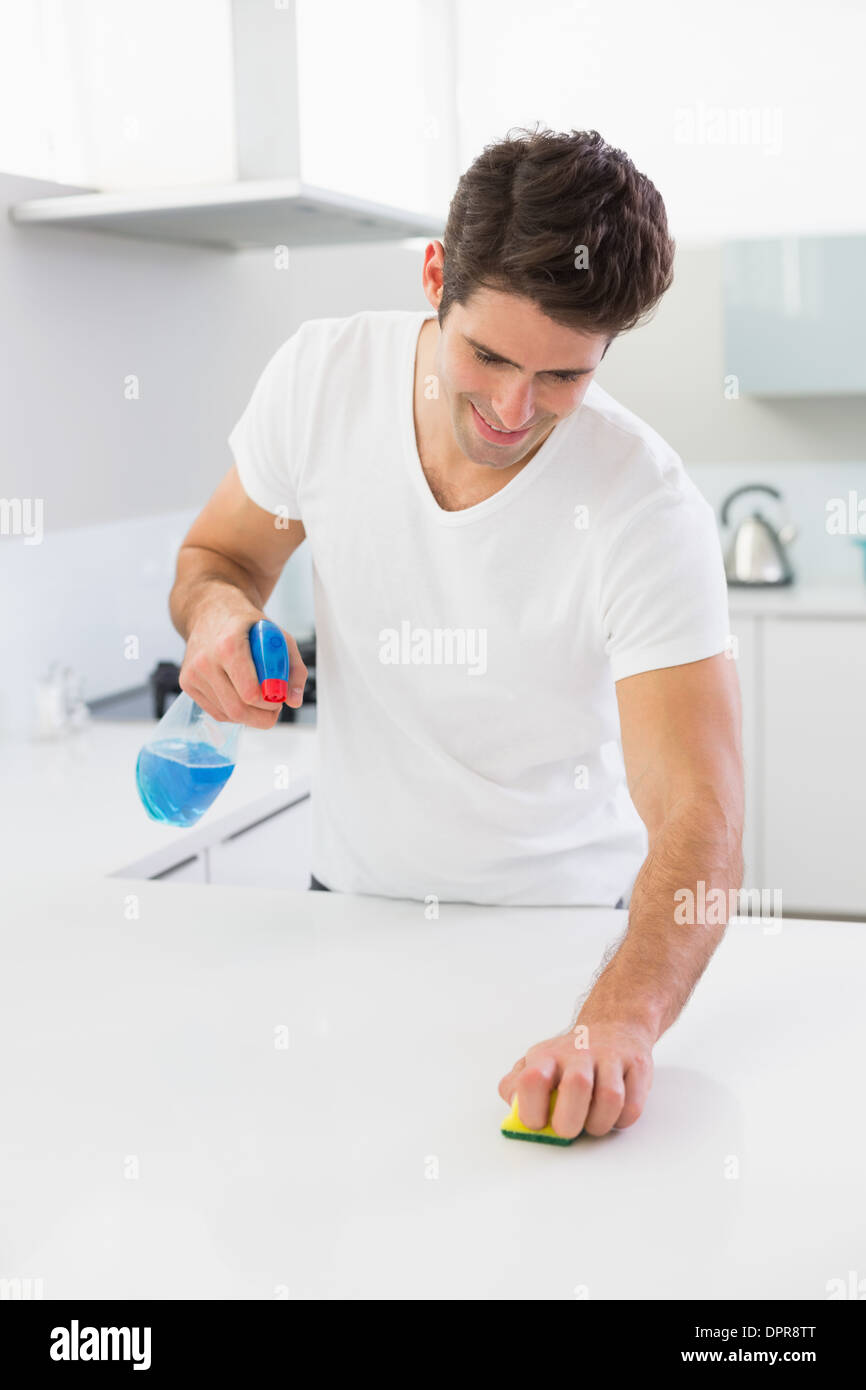 Smiling man cleaning kitchen counter in house Stock Photo - Alamy
