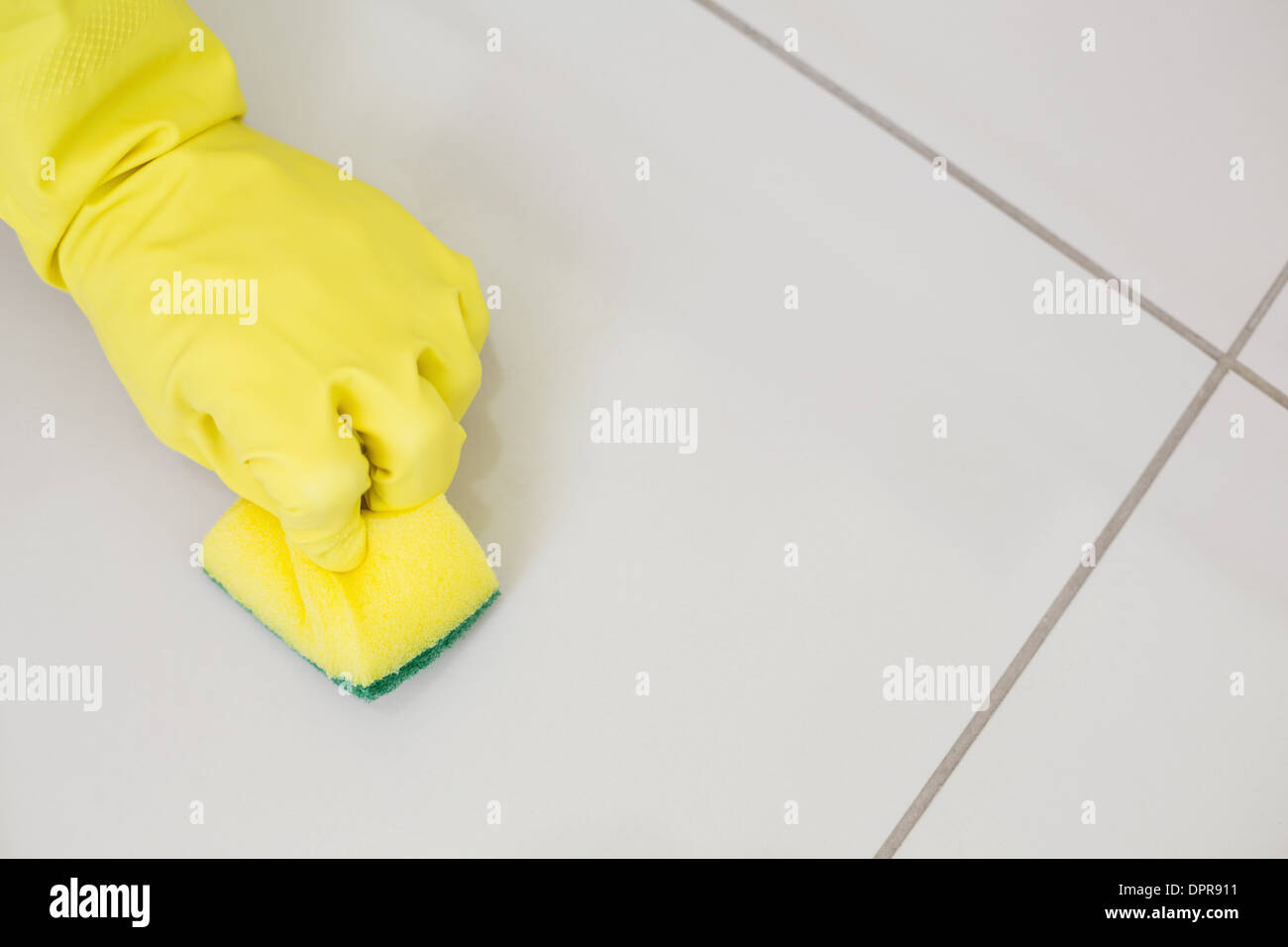 Yellow gloved hand with sponge cleaning the floor Stock Photo - Alamy