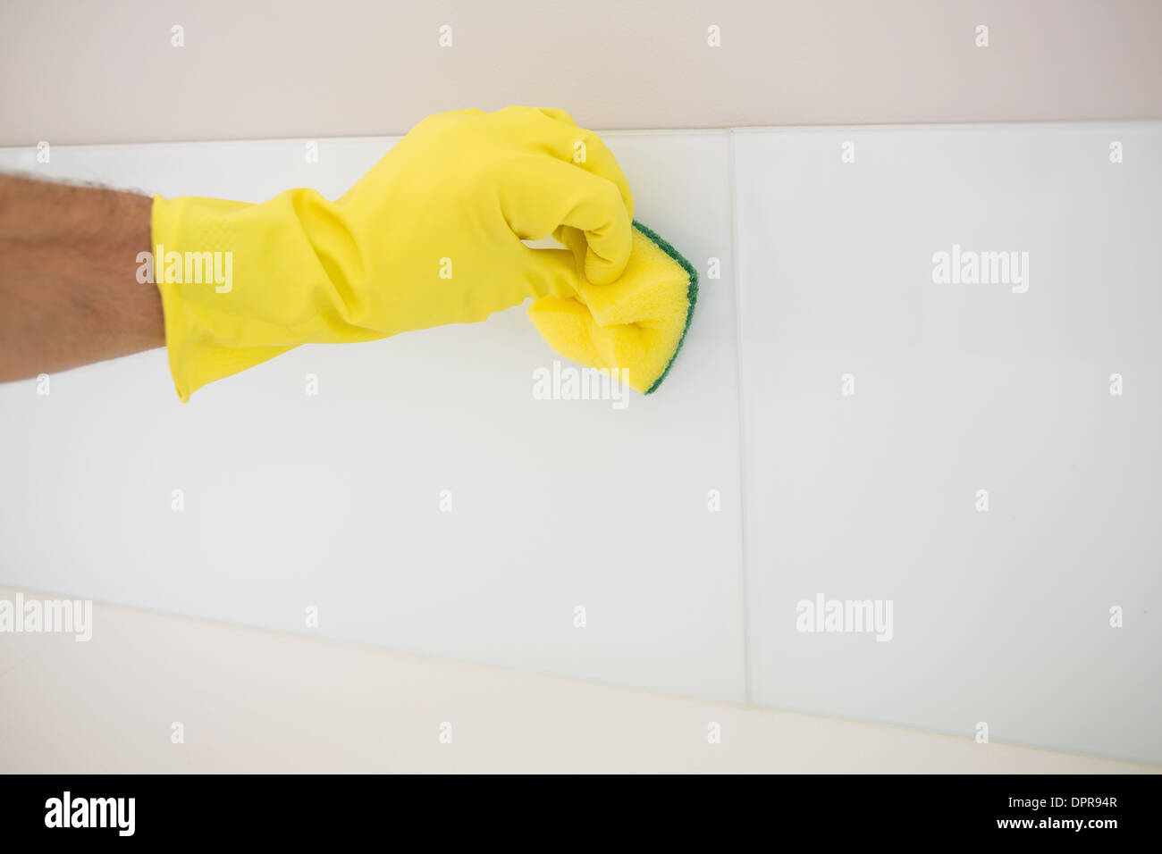 Yellow gloved hand with sponge cleaning the floor Stock Photo - Alamy