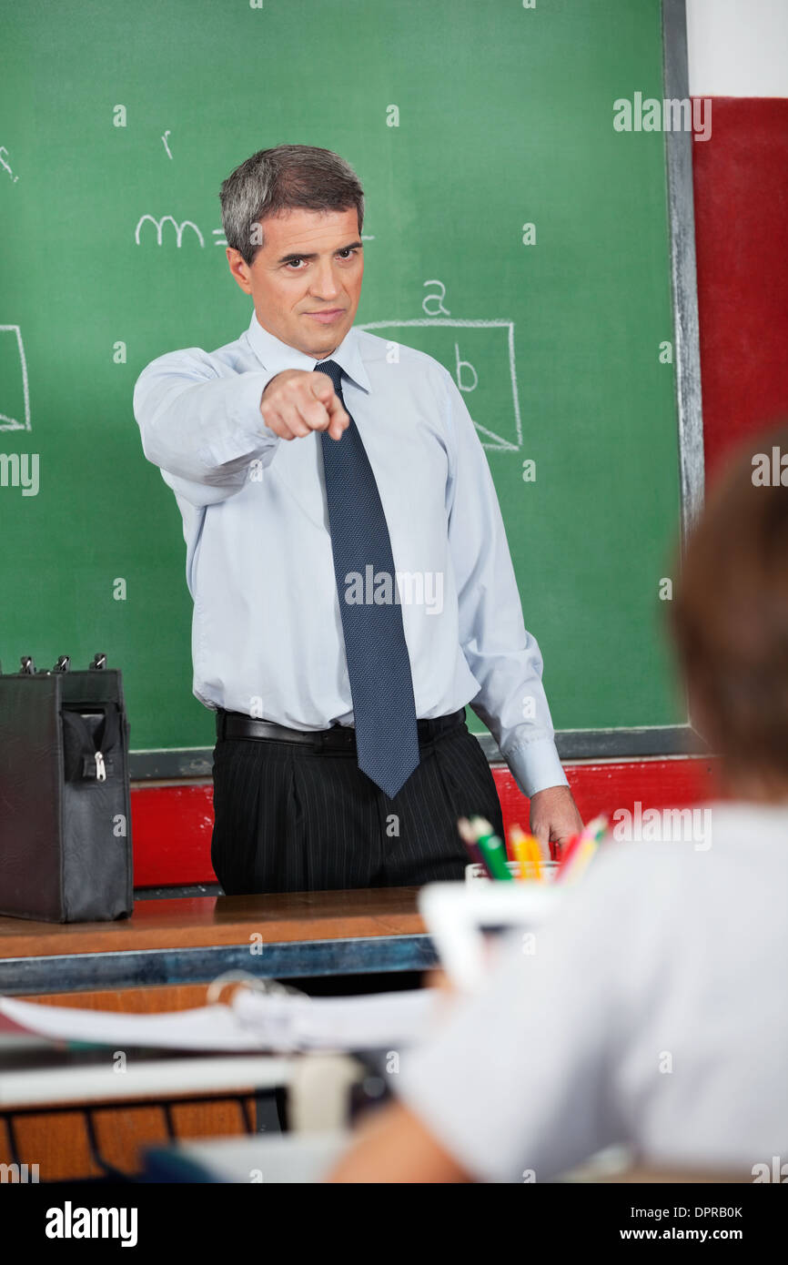 Teacher pointing boy raised hand hi-res stock photography and images ...