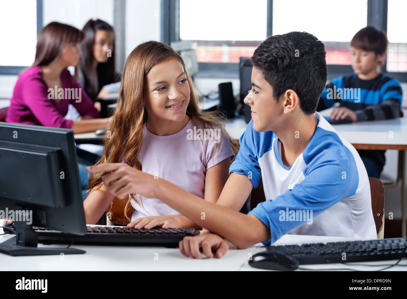Friends Looking At Each Other While Using Computer Stock Photo - Alamy