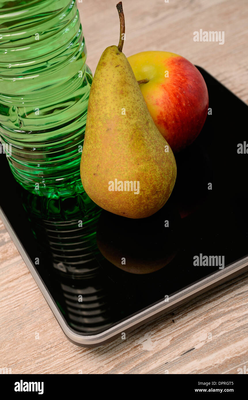 Fresh fruits and a bottle of water on a scale Stock Photo - Alamy