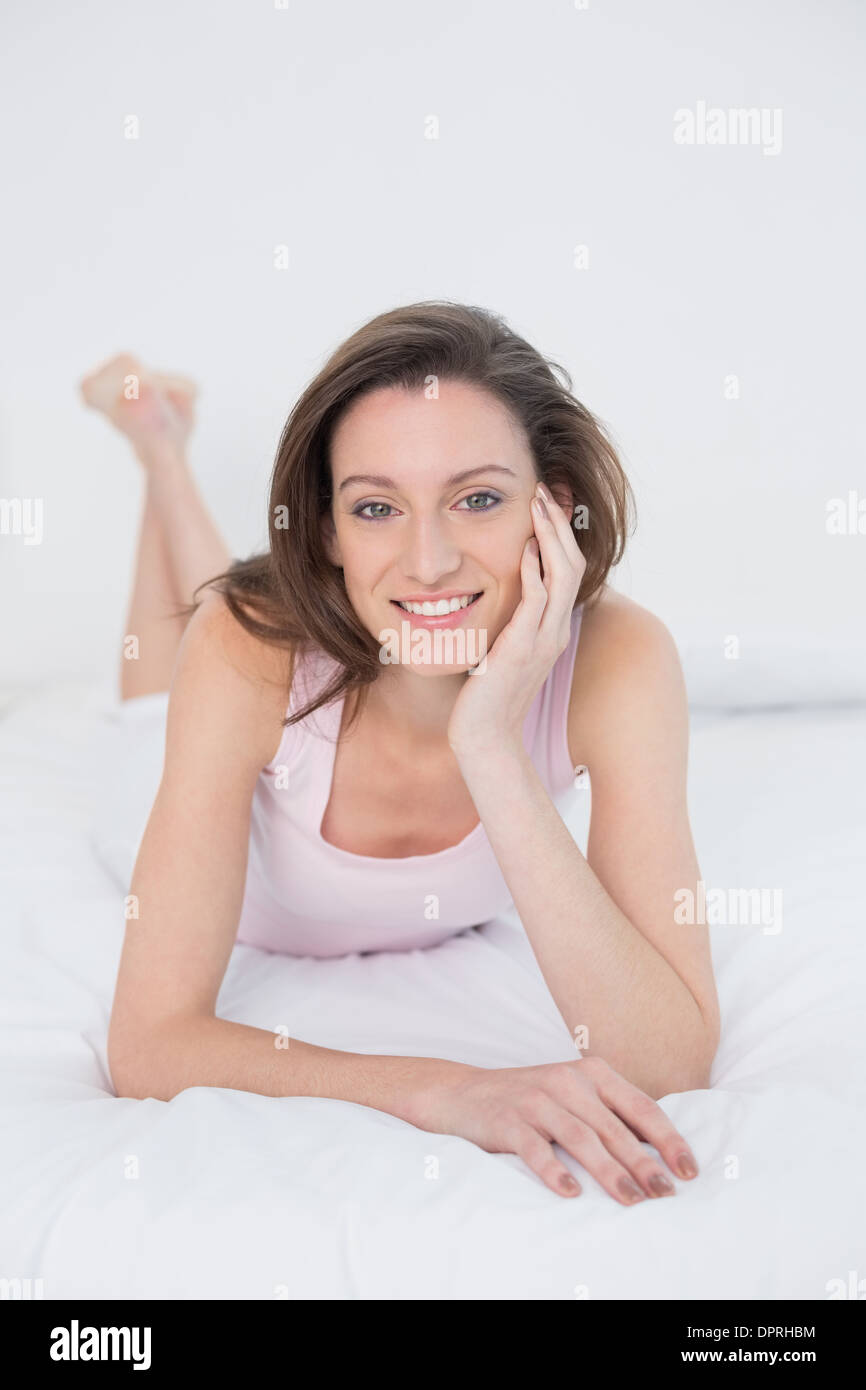 Smiling young woman resting in bed Stock Photo - Alamy