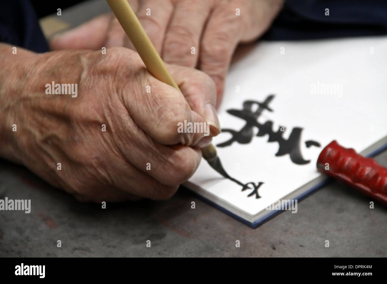 An old Buddhist monk writing beautiful characters in Japanese at ...