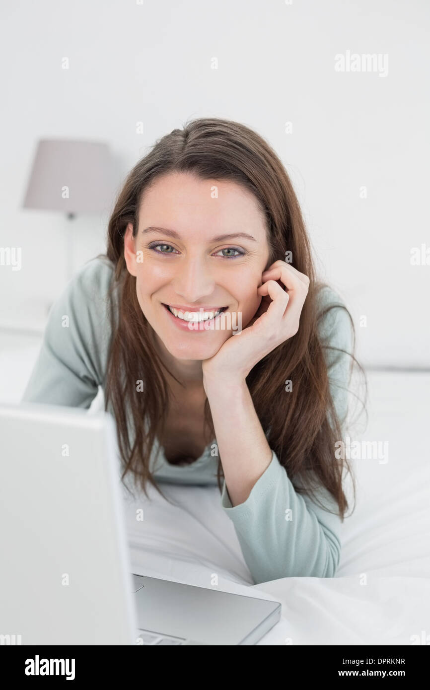 Happy relaxed casual woman using laptop in bed Stock Photo - Alamy