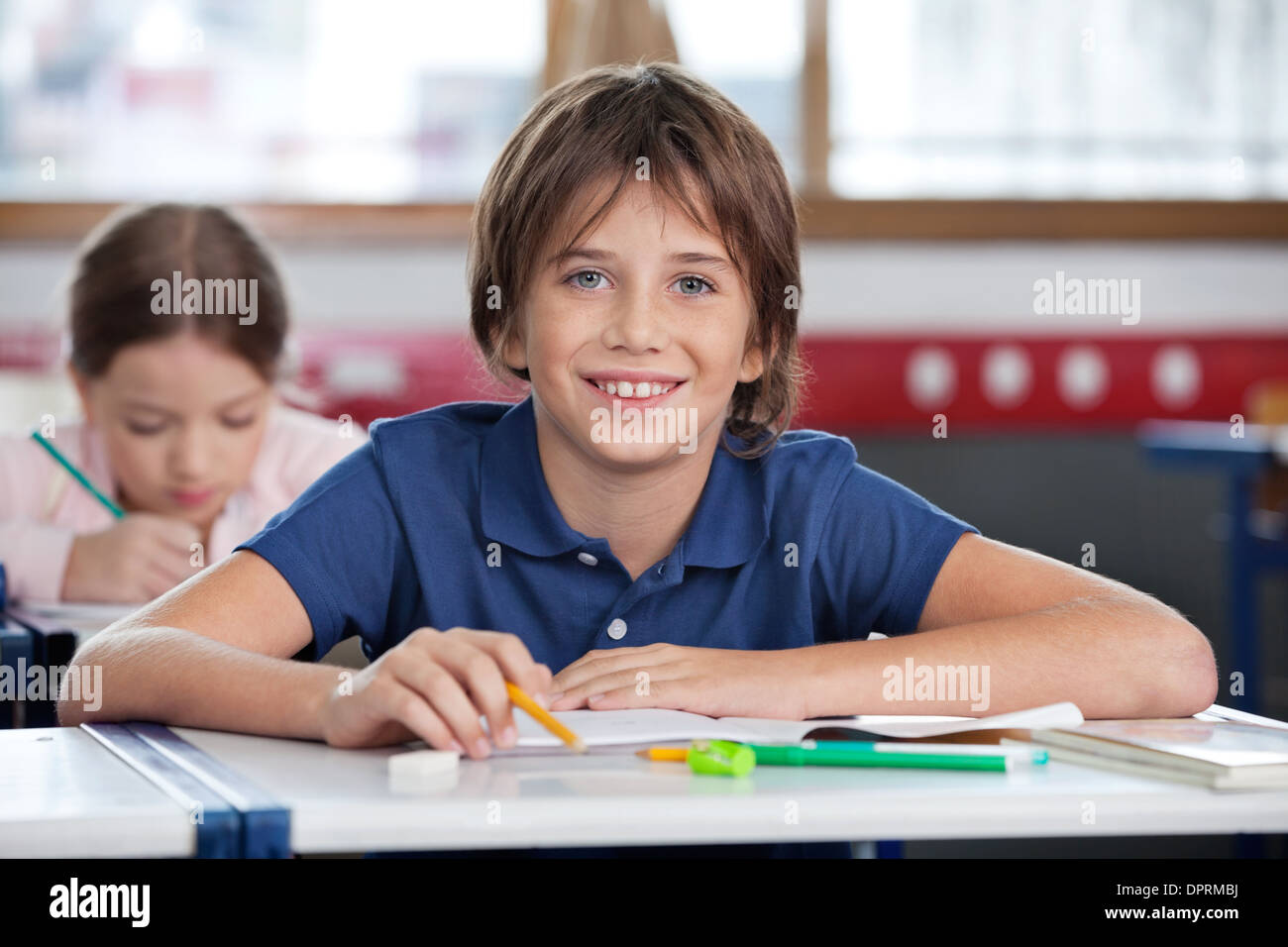 Cute Schoolboy Smiling In Classroom Stock Photo - Alamy