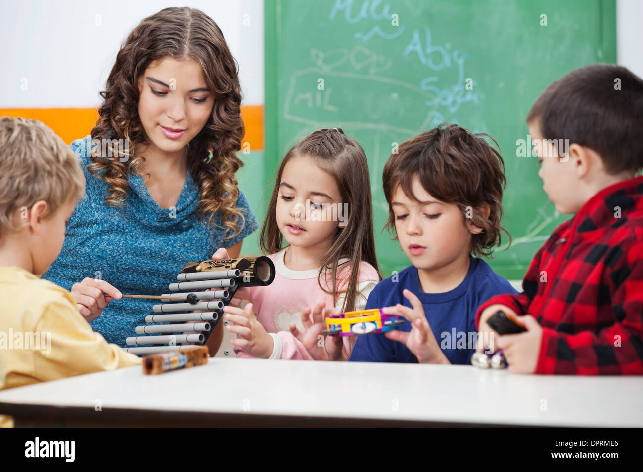 Teacher Teaching Students To Play Xylophone In Class Stock Photo - Alamy