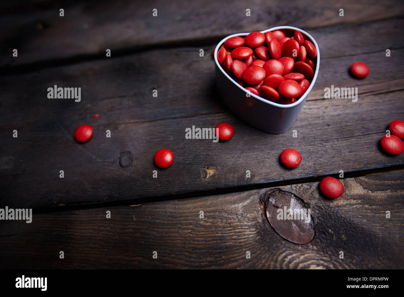Red small candies in heart shaped box against wooden background Stock ...