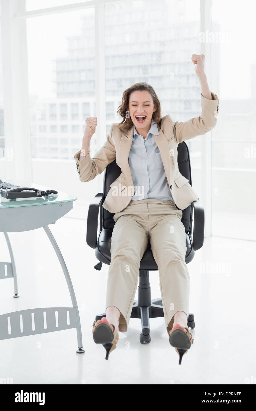Businesswoman cheering with hands raised in office Stock Photo - Alamy
