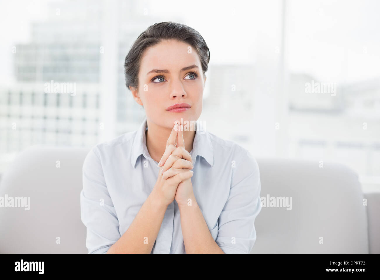 Serious well dressed young woman looking up Stock Photo - Alamy