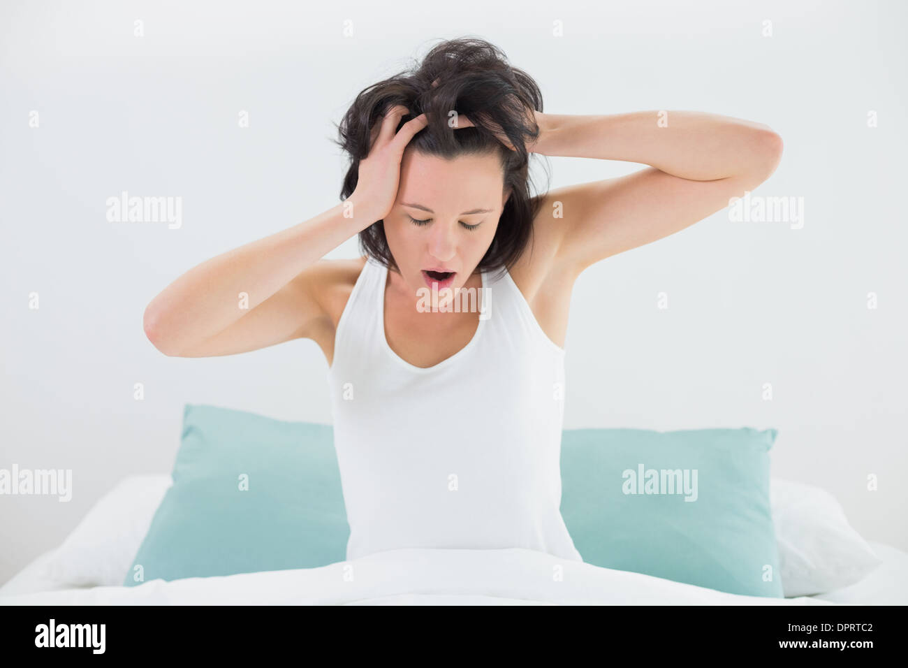 Sleepy woman yawning while stretching her arms in bed Stock Photo - Alamy