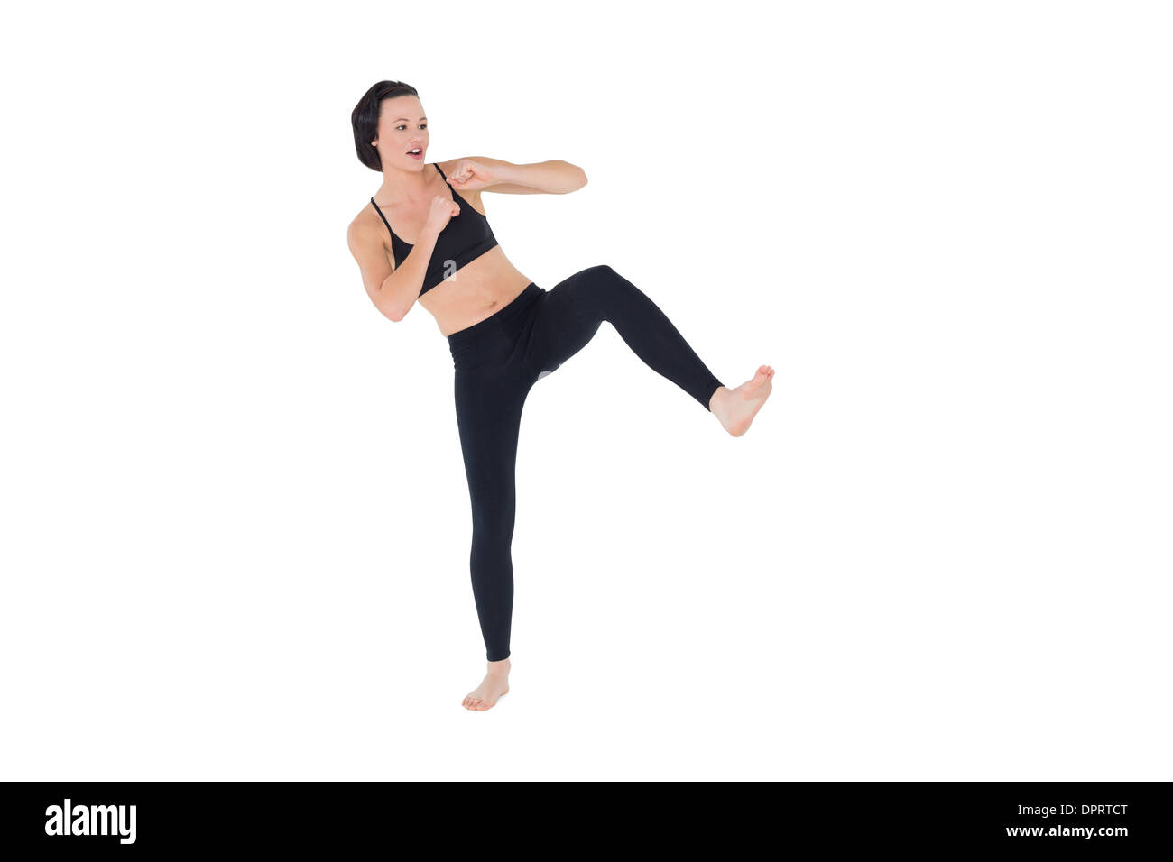 Full length of a sporty young woman air kicking Stock Photo - Alamy